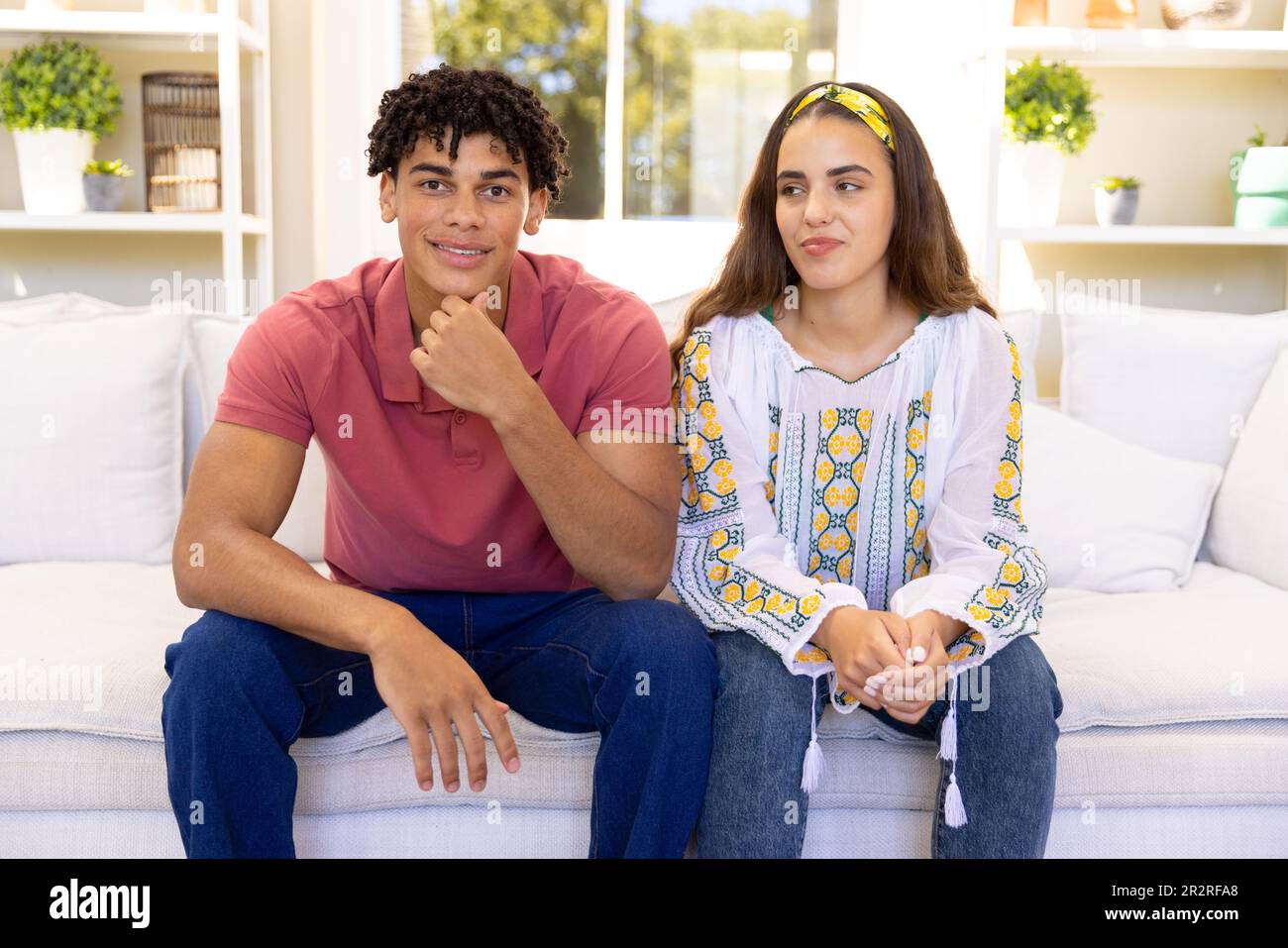 Portrait of smiling handsome young boyfriend sitting with girlfriend on ...