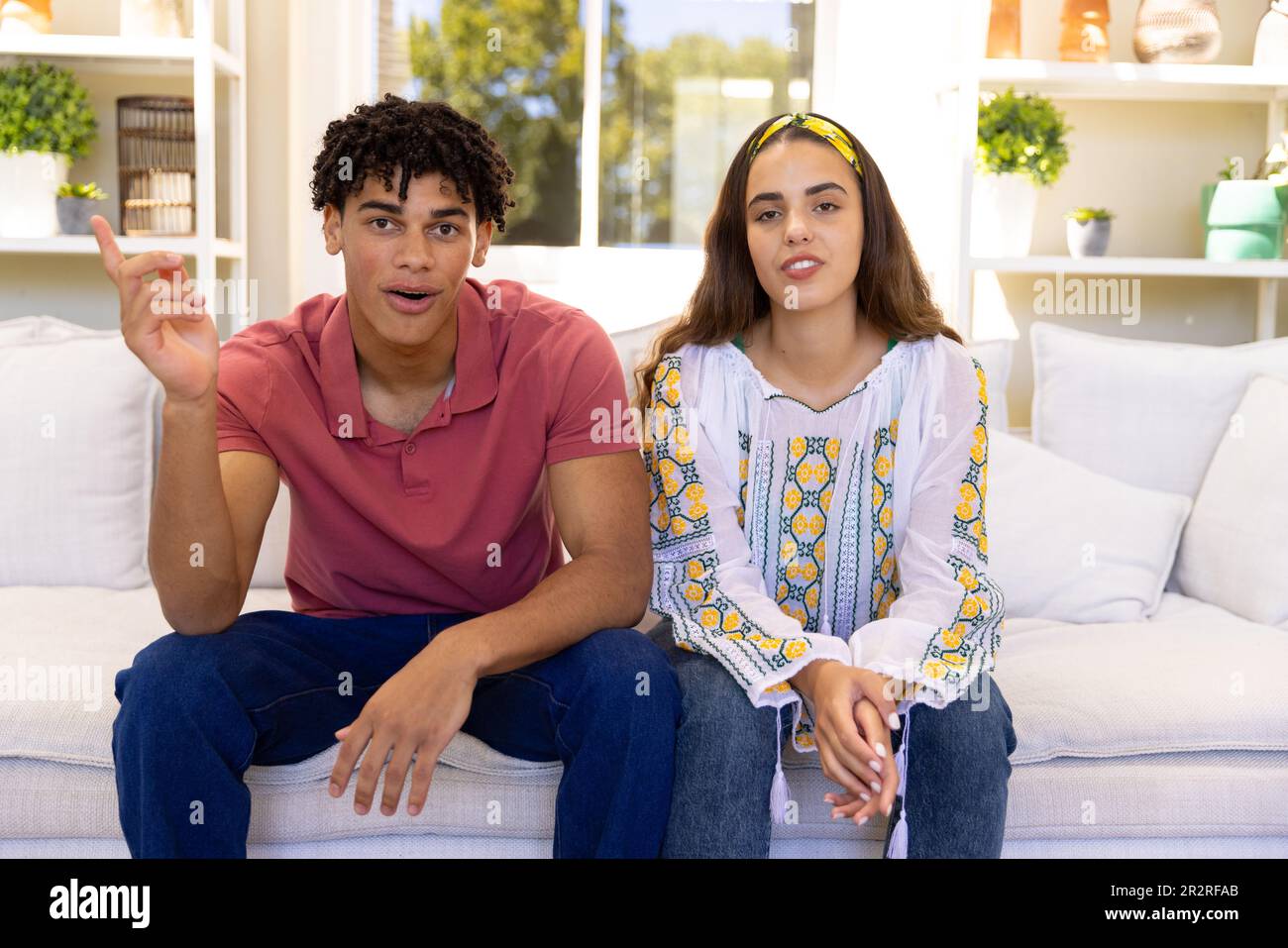 Portrait of handsome young boyfriend and beautiful girlfriend sitting ...