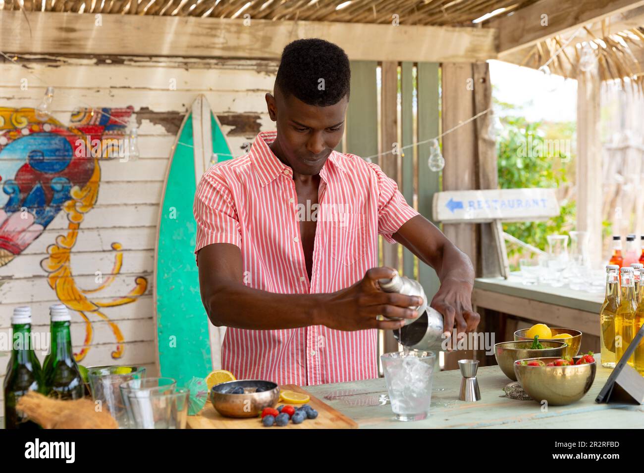 African american male bartender holding shaker and preparing cocktails ...