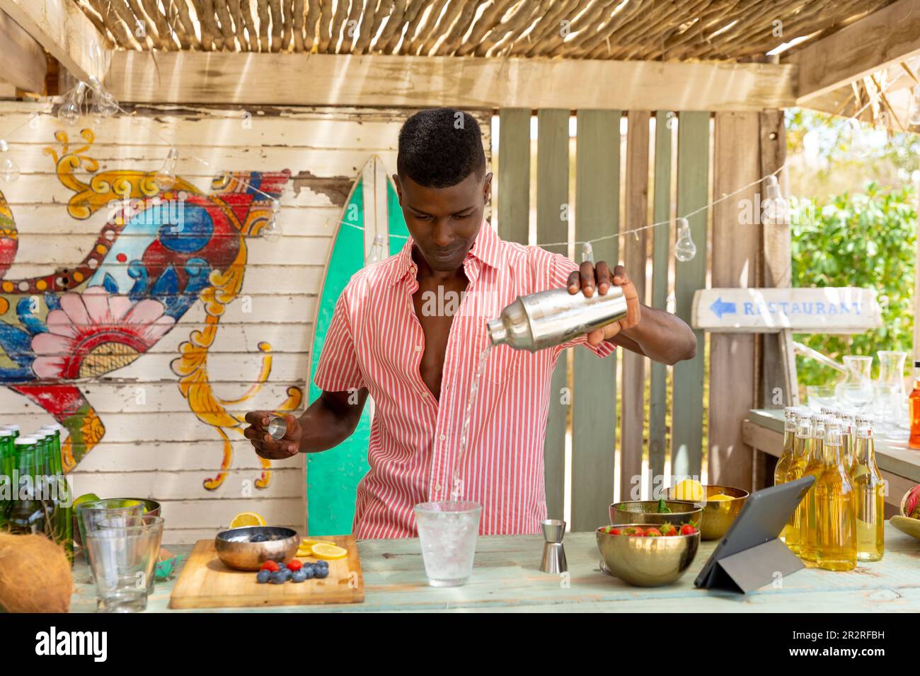 African american male bartender holdind shaker and preparing cocktails ...