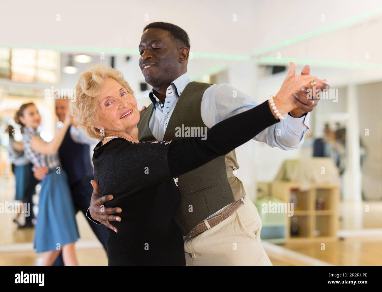Elderly woman learning ballroom dancing in pair in dance studio Stock ...