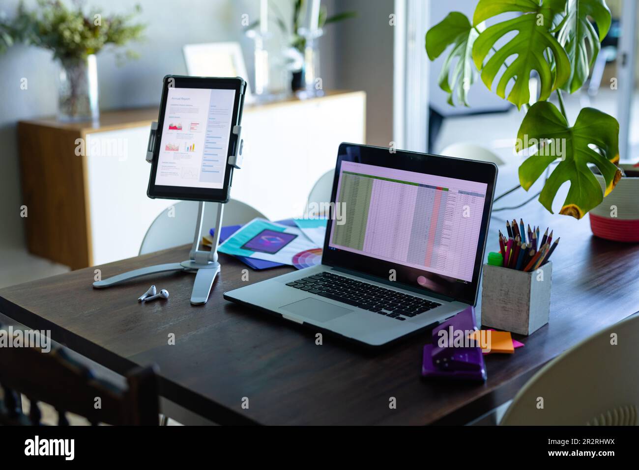 Laptop and tablet, with spreadsheet and document on screen, on dining ...