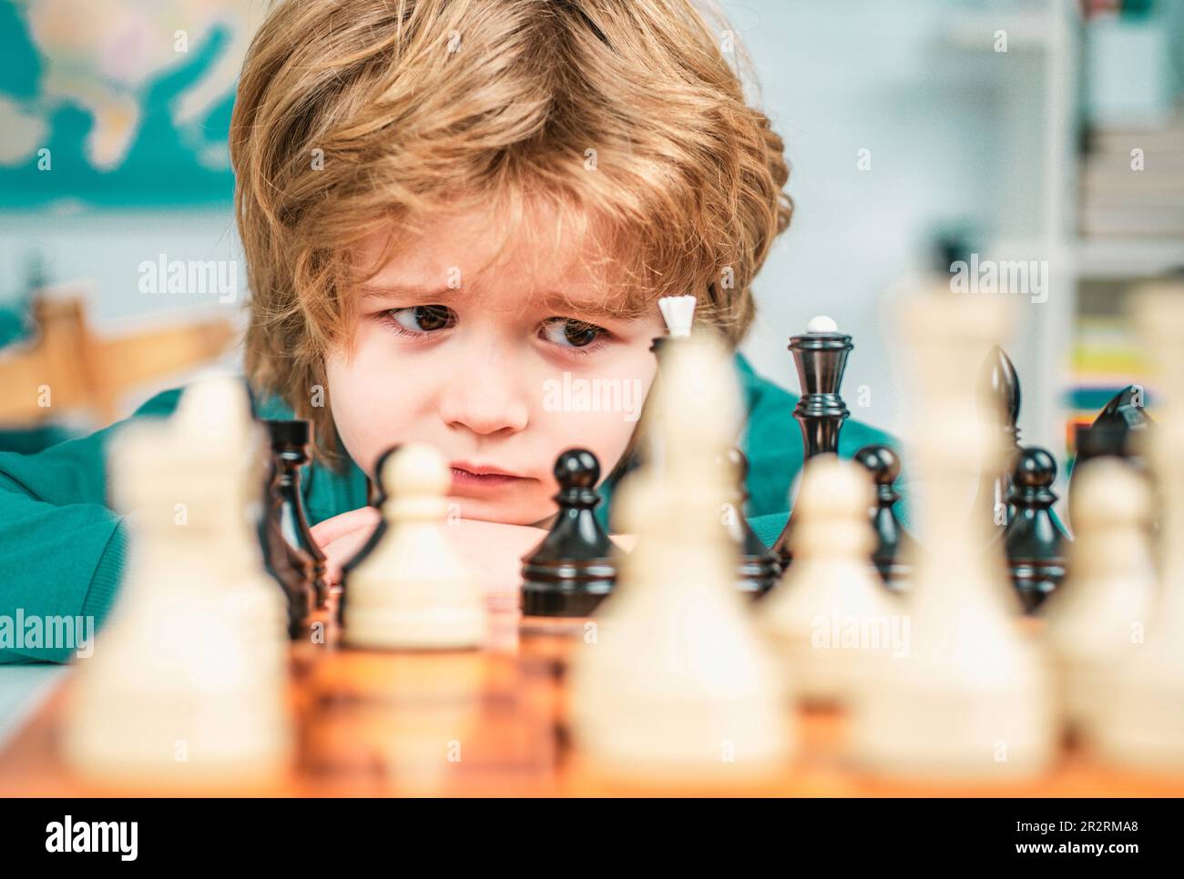 Cute little boy playing chess. Thinking kid. Concentrated boy ...