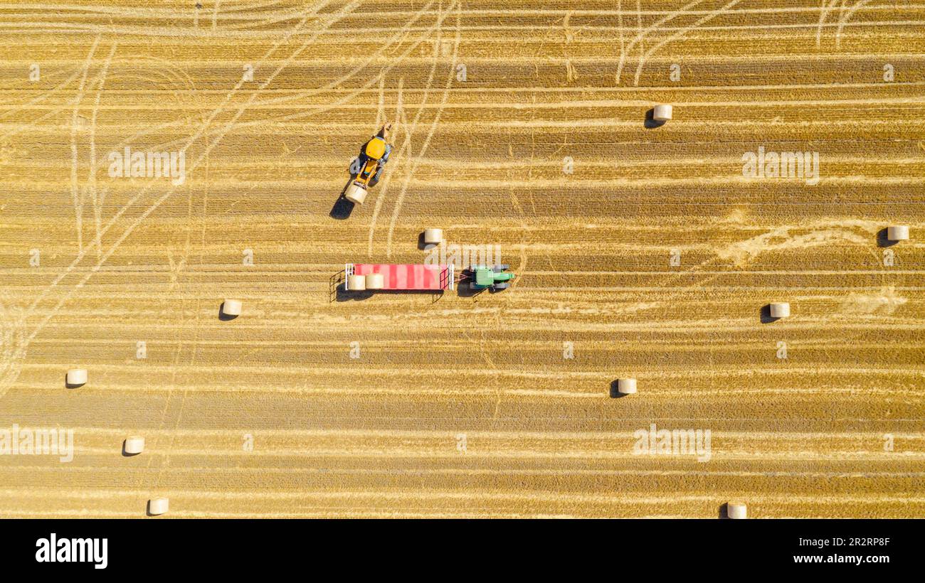 Above top view on excavator as loading straw bales on trailer, tow by ...