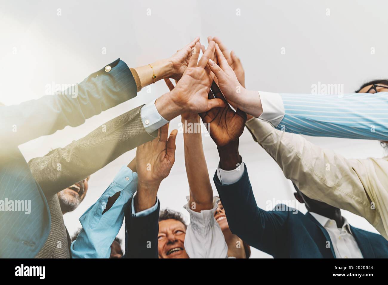 Low-angle shot of a diverse team of colleagues standing together in a ...