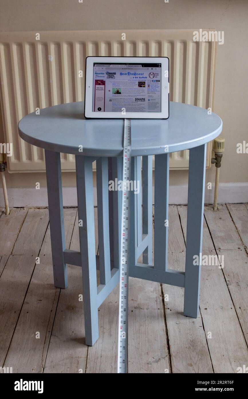 iPad on a pale blue occasional table with an expanding steel rule ...