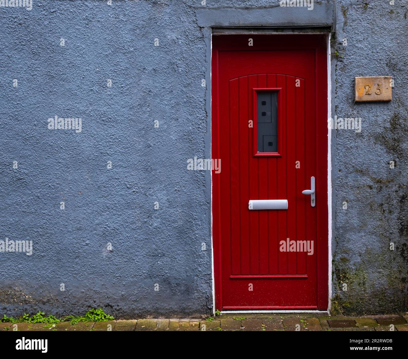 Traditional English house facade front entrance with red closed door ...