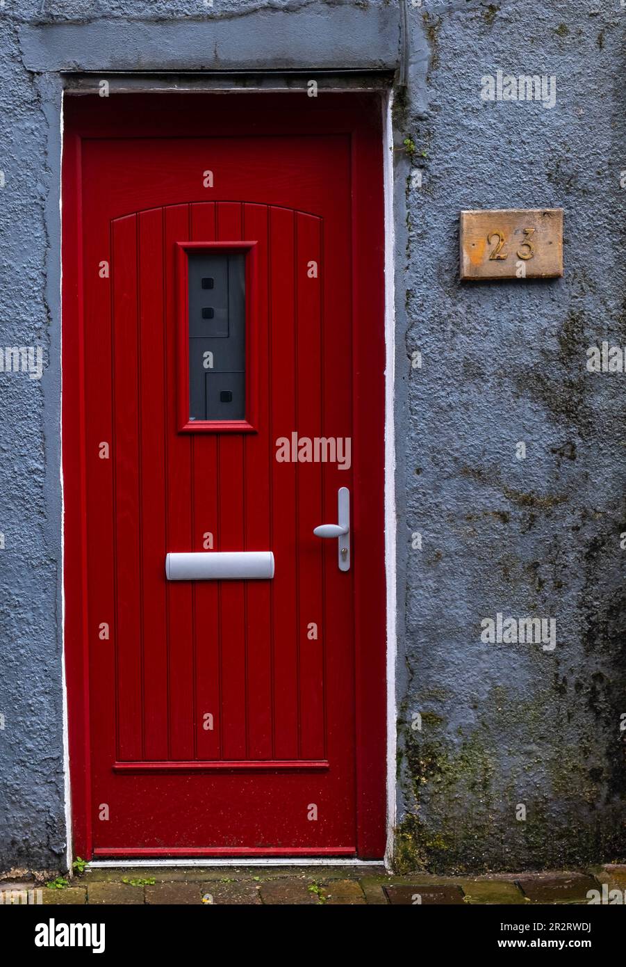 Traditional English house facade front entrance with red closed door ...