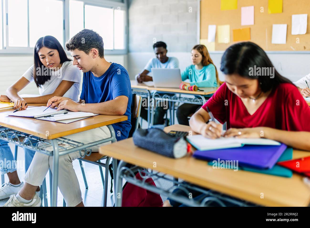 Young group of diverse students studying in classroom at high school ...