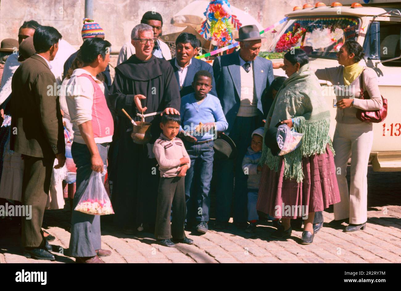 The priest poses with families at the Blessing of the vehicles ...