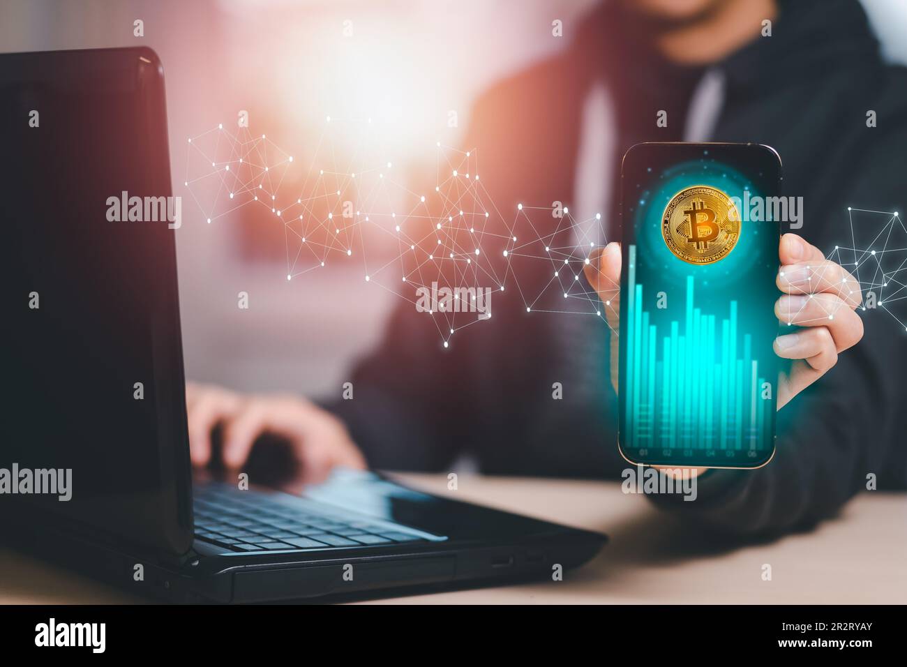 Smartphone with Bitcoin chart on-screen among piles of Bitcoin concept ...