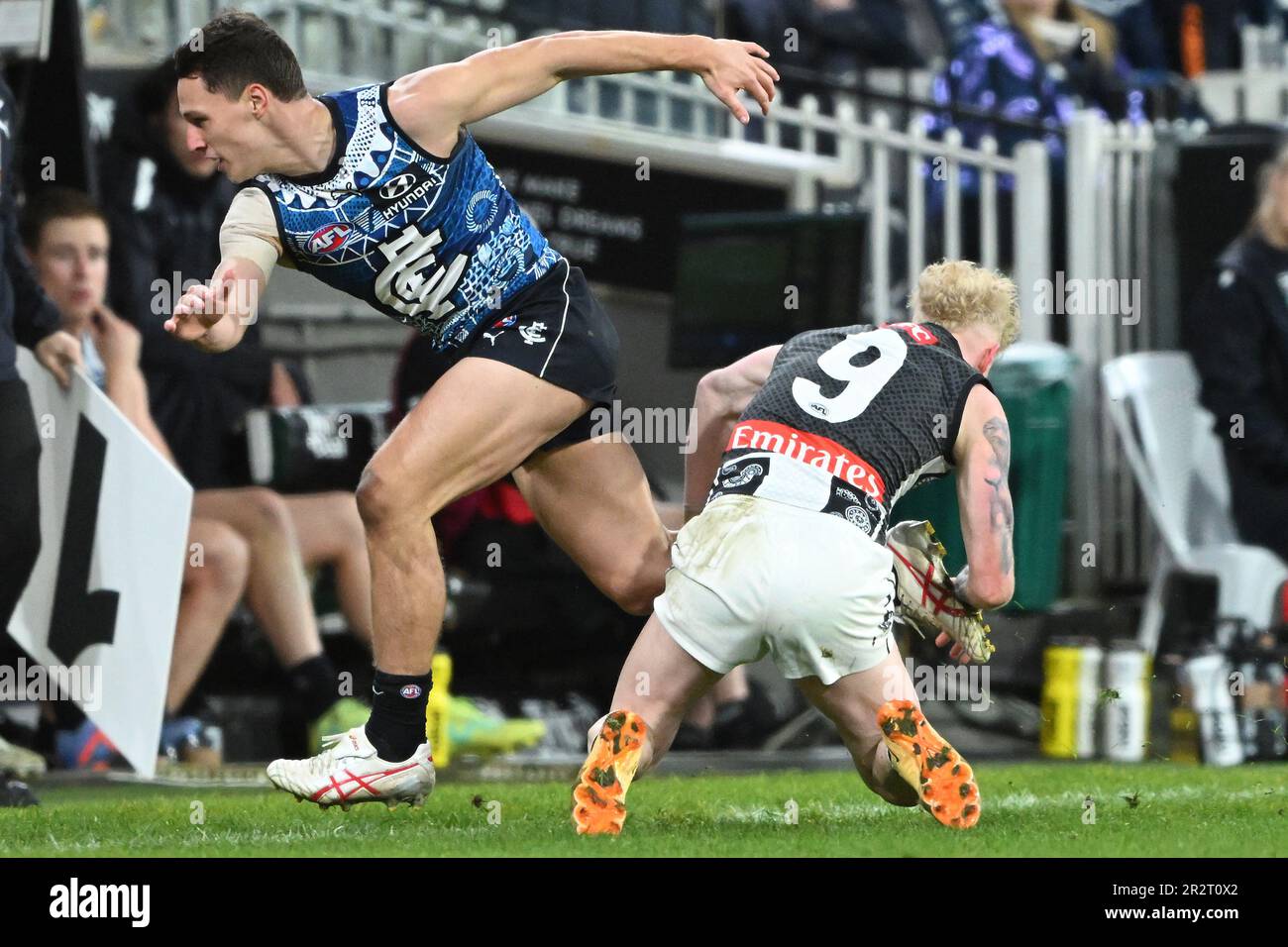 Corey Durdin of Carlton (left) is bumped by John Noble of Collingwood ...