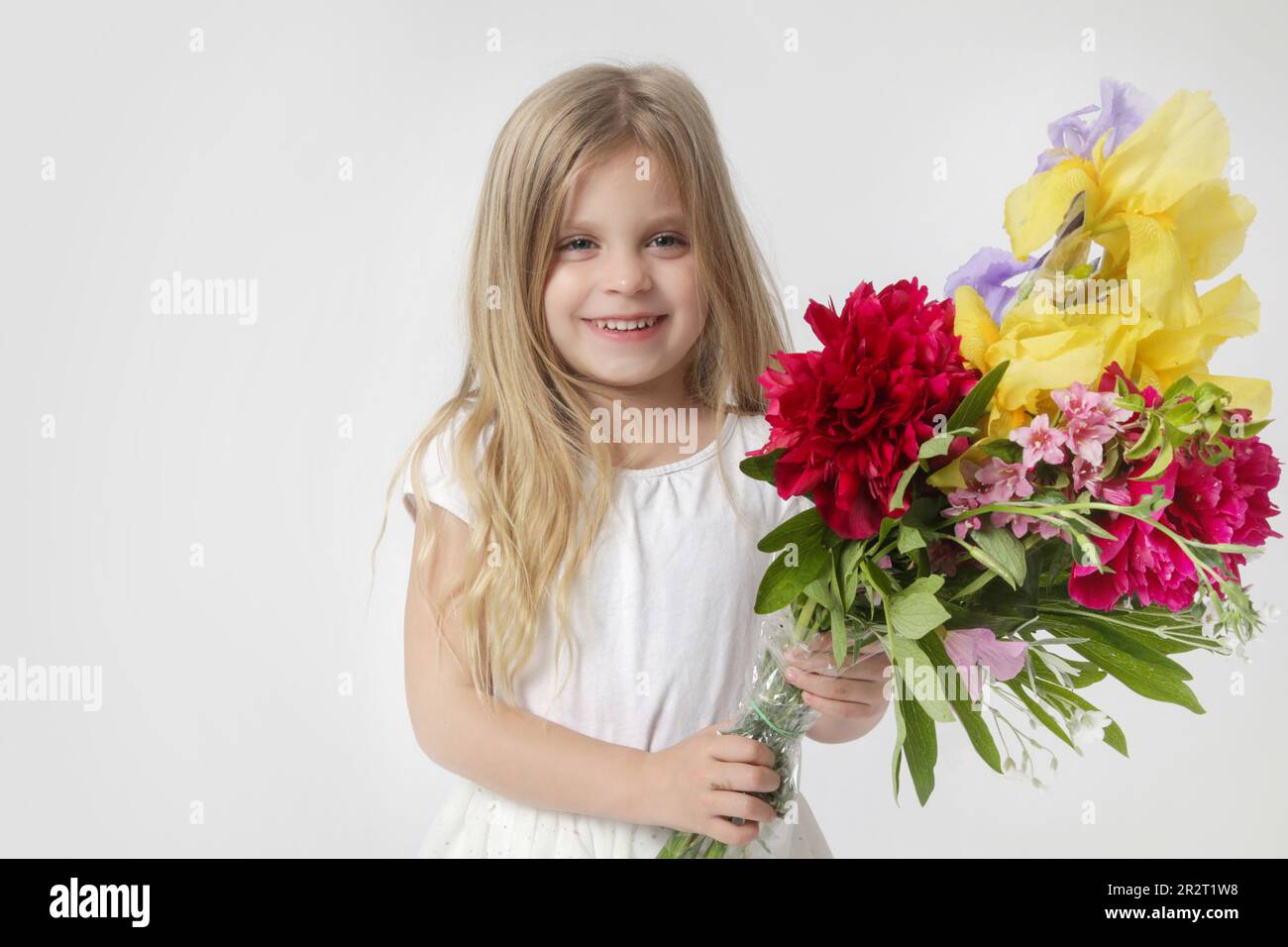 Studio portrait of beautiful little girl holding big colorful bouquet ...