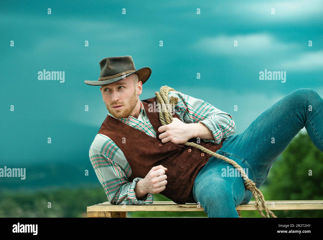 Cowboy on ranch. Handsome man in cowboy hat and retro vintage outfit ...