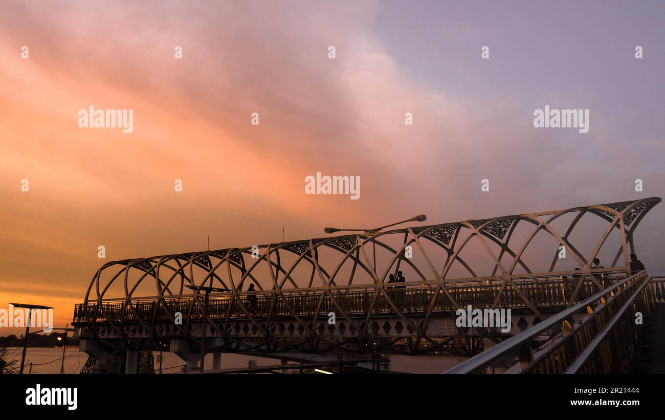 Sunset with beautiful expanse of clouds and the silhouette of a bridge ...
