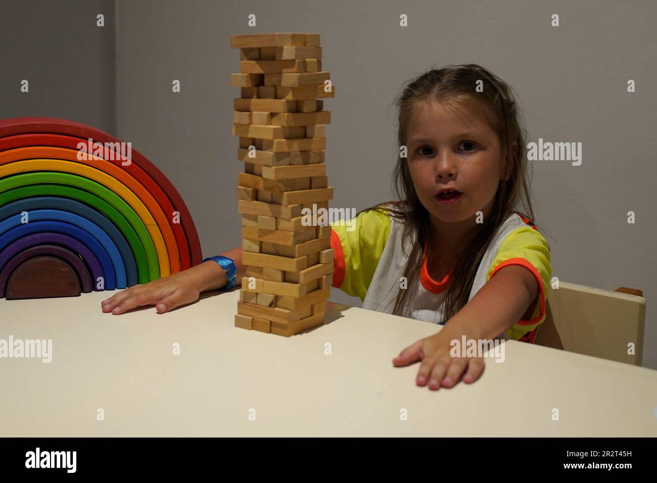 A little girl builds a pyramid of blocks. The concept of early ...