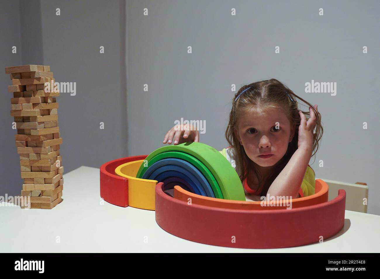 A little girl builds a pyramid of blocks. The concept of early ...