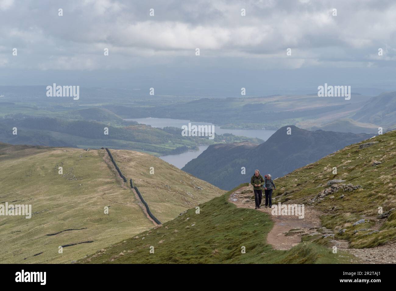 Walkers on the path to striding edge, Helvellyn, with ullswater lake ...