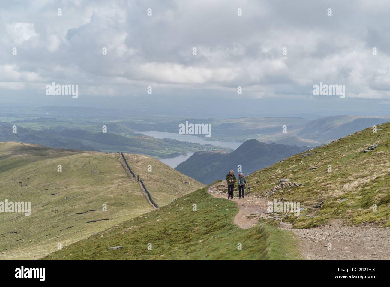 Walkers on the path to striding edge, Helvellyn, with ullswater lake ...