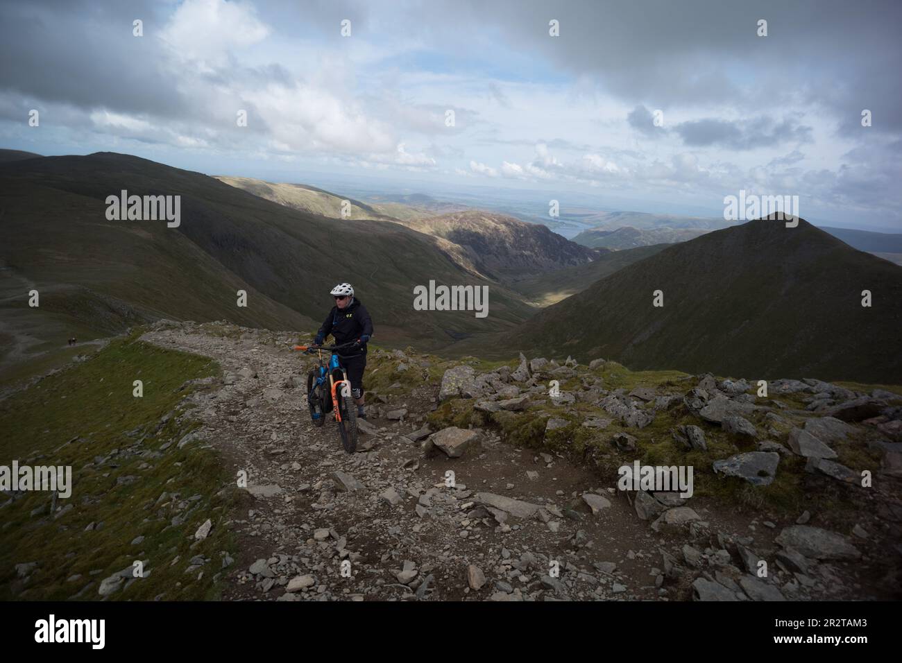man pushing electric bike up Helvellyn Mountain, english lake district ...