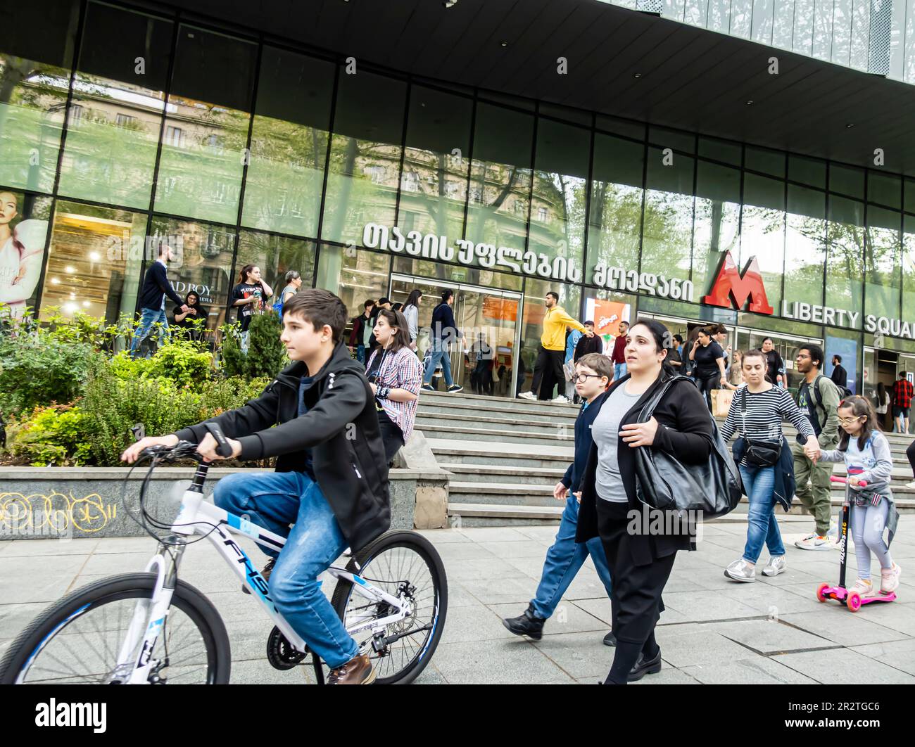 People passig by, Young people on a bicycle, Liberty Square metro ...