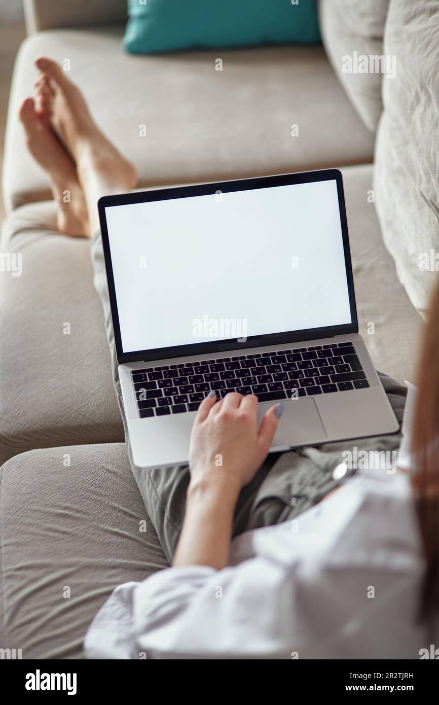 Mockup white screen laptop woman using computer lying on sofa at home ...