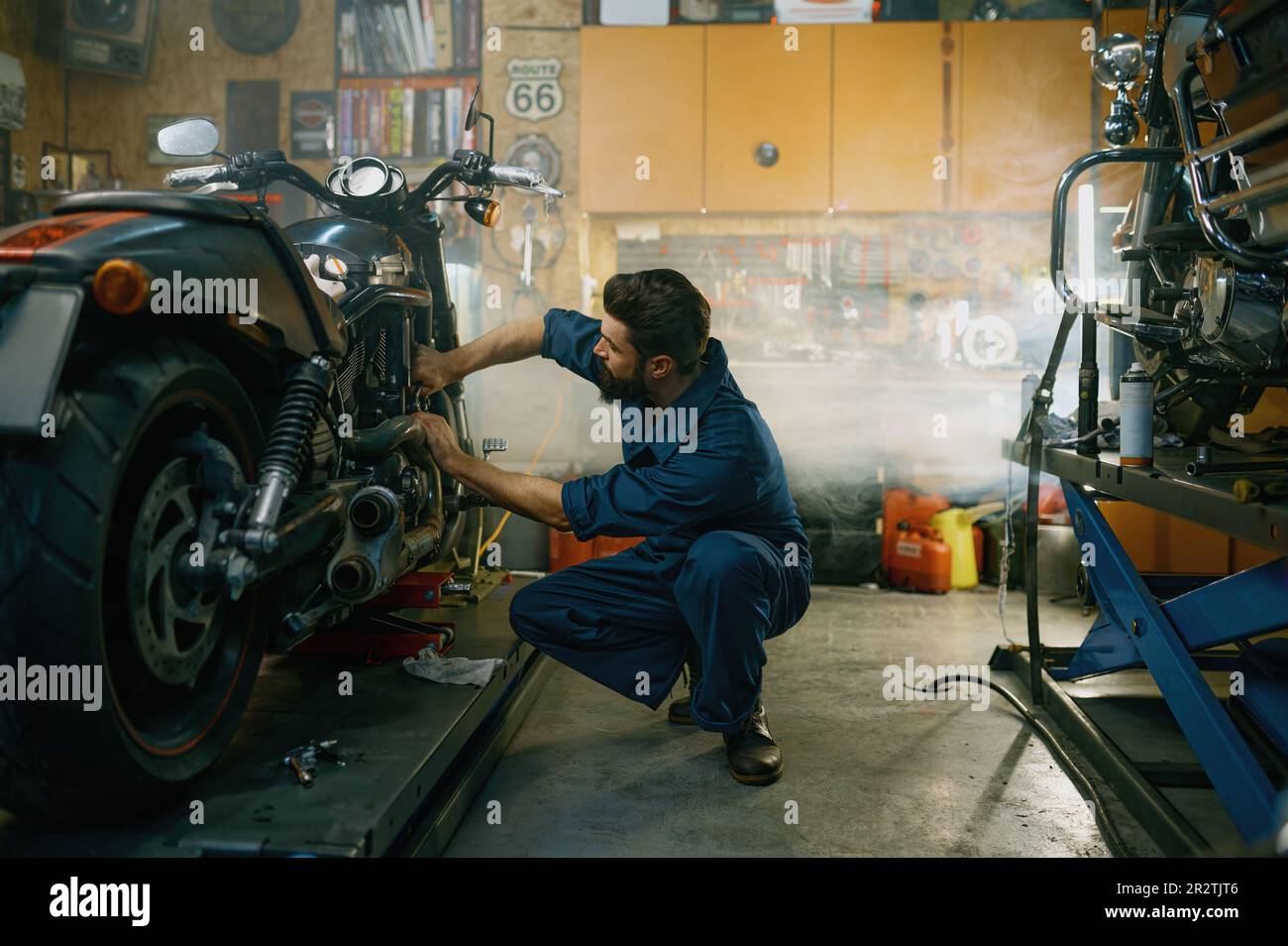 Young mechanic working on motorcycle in garage repair service Stock ...