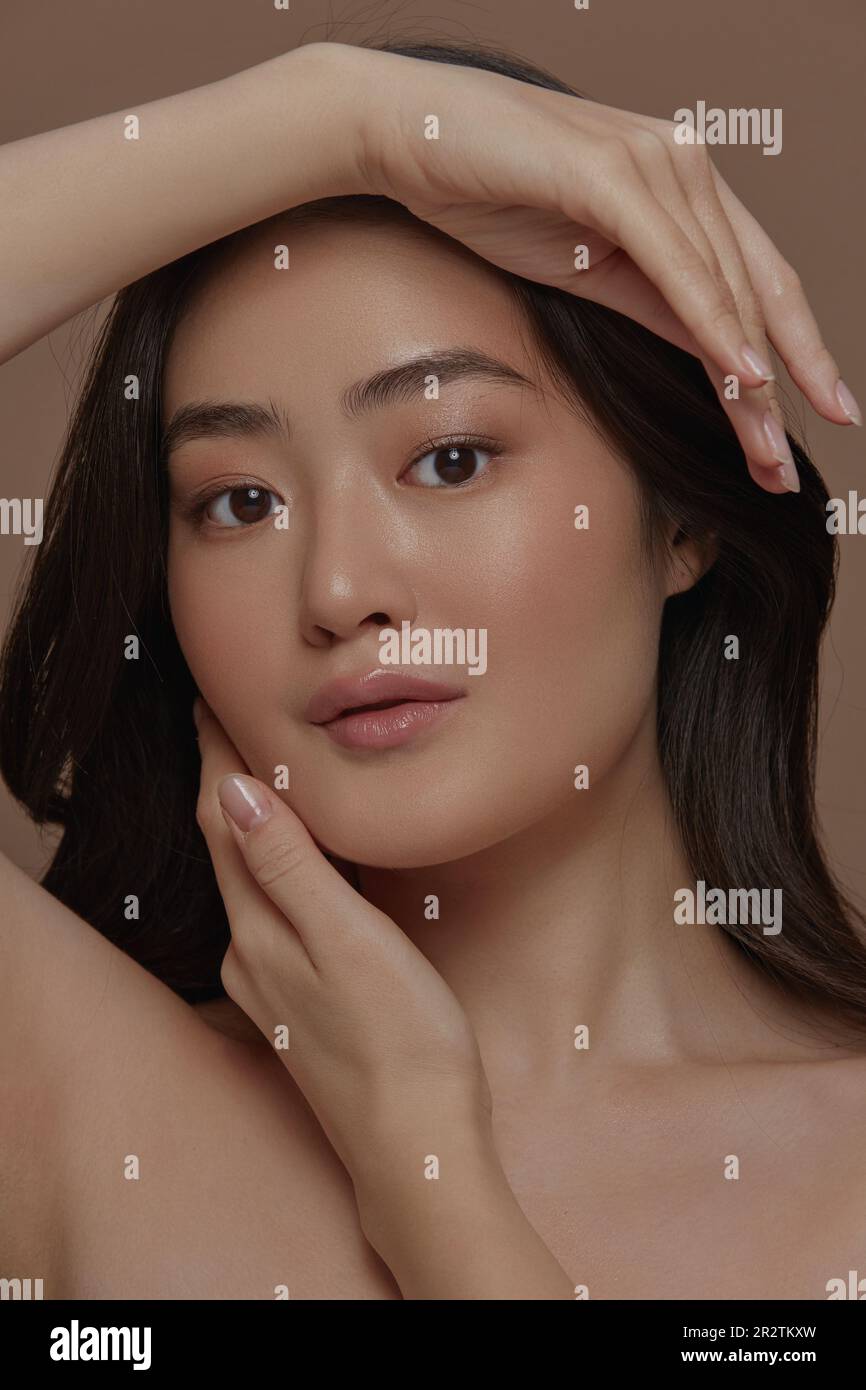 Beautiful Korean woman with perfectly clean healthy skin holding her ...