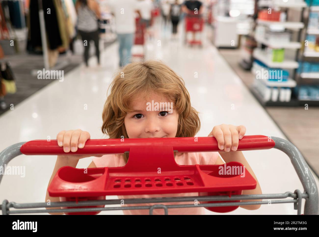Close up portrait of child with shopping basket purchasing food in a ...