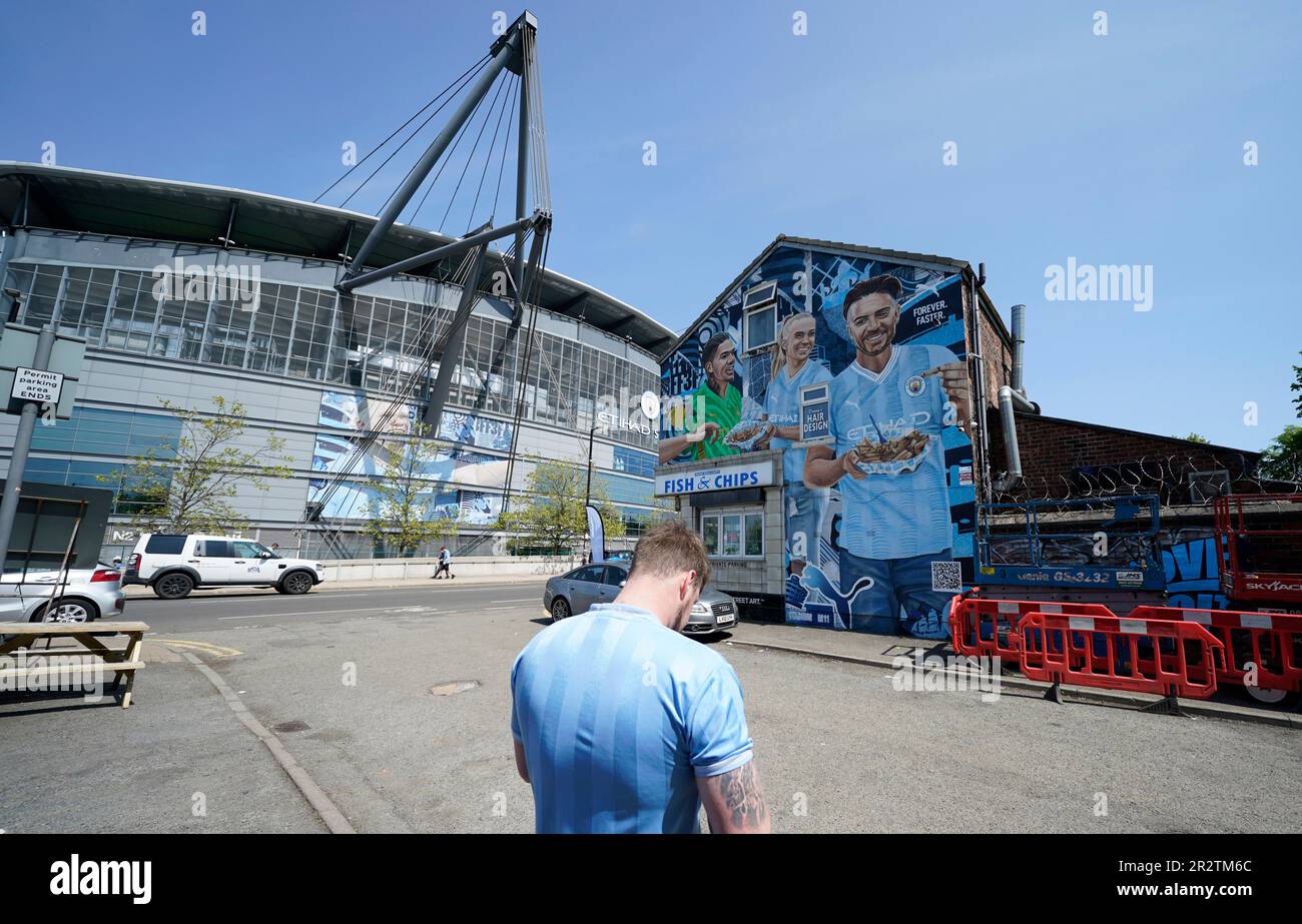 Manchester, UK. 21st May, 2023. Fans take pictures of the mural on the ...