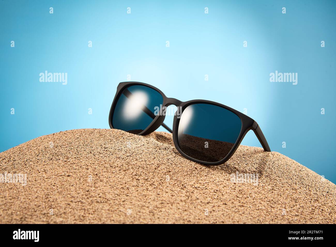Sunglasses, shades with black frame, lenses in sand Stock Photo - Alamy