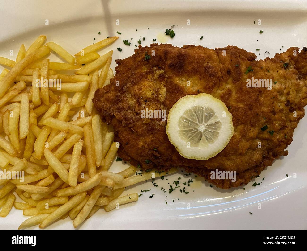 Viennese schnitzel with french fries and lemon. Viennese breaded ...