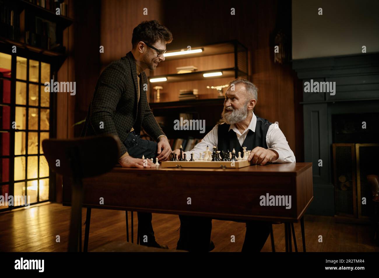 Happy intelligent family playing chess spending time together at home ...
