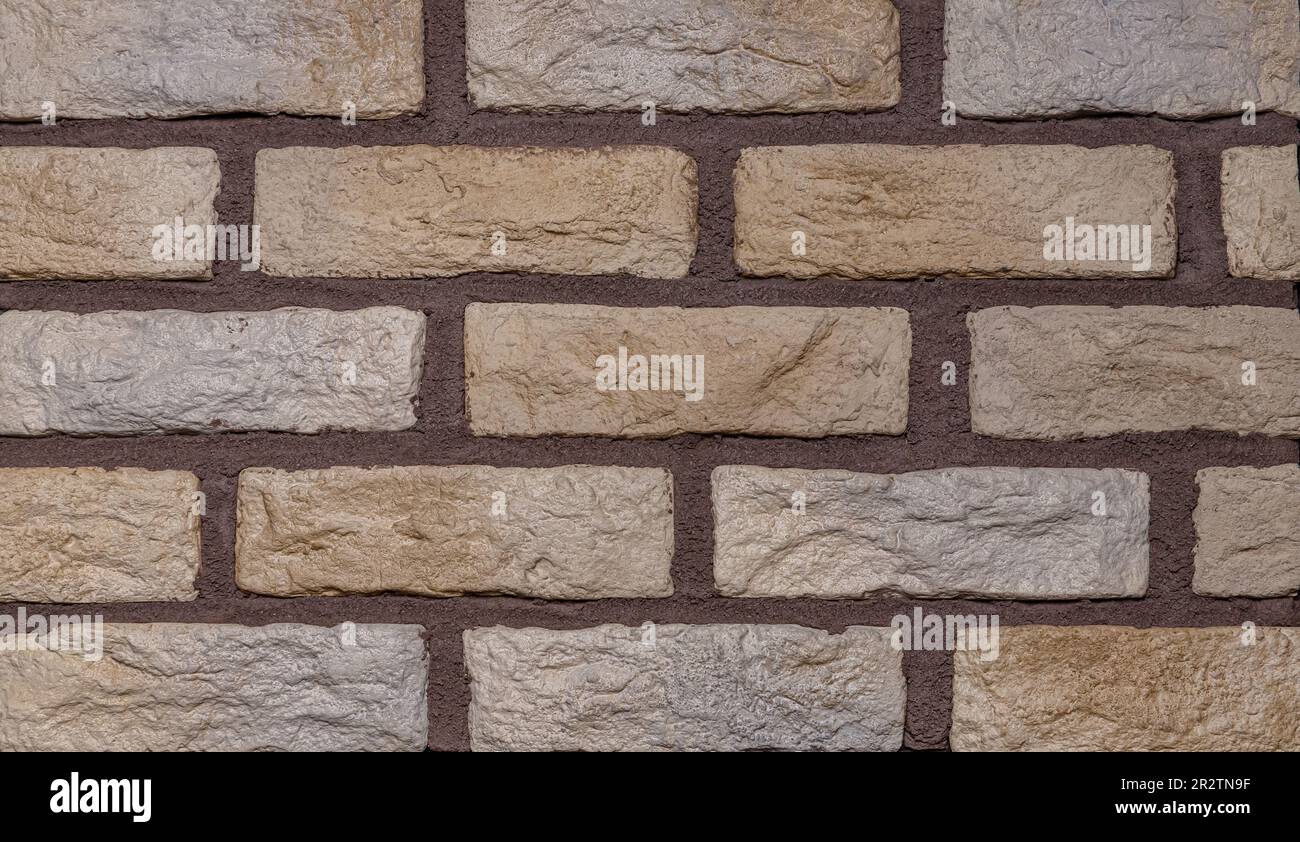 The texture of the wall is made of beige natural stone blocks or brick ...