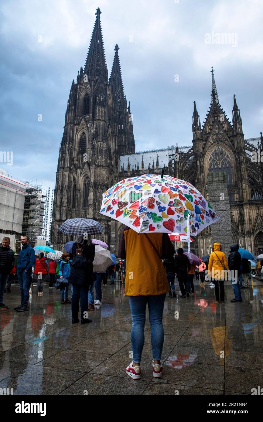 people standing in the rain at Roncalliplatz in front of the cathedral ...