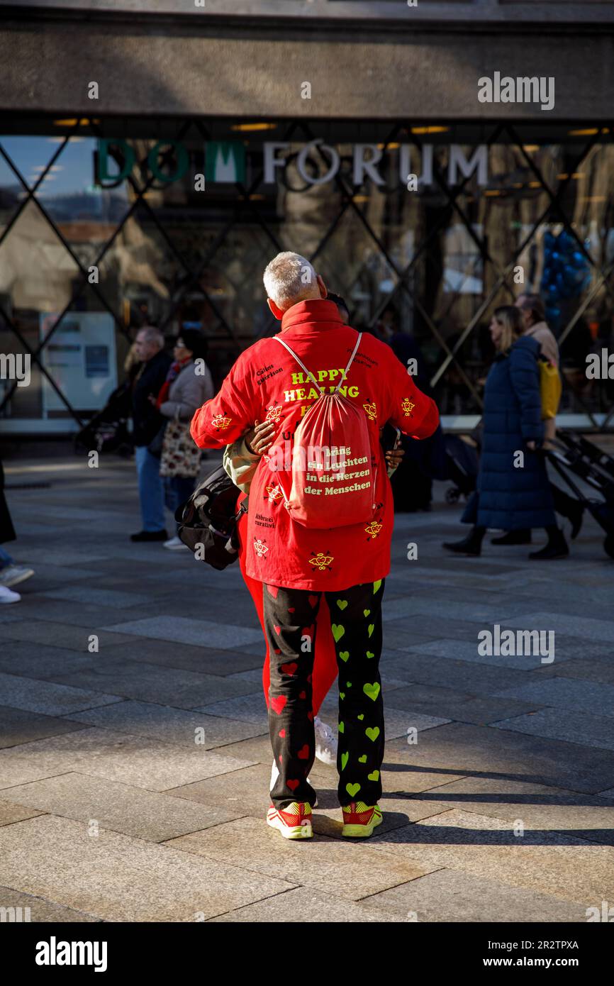 wearing a jacket with the inscription Happy Healing Hugs a man stands ...