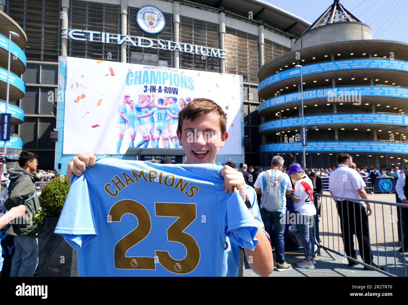 A Manchester City fan poses for a photo in front of a banner ...