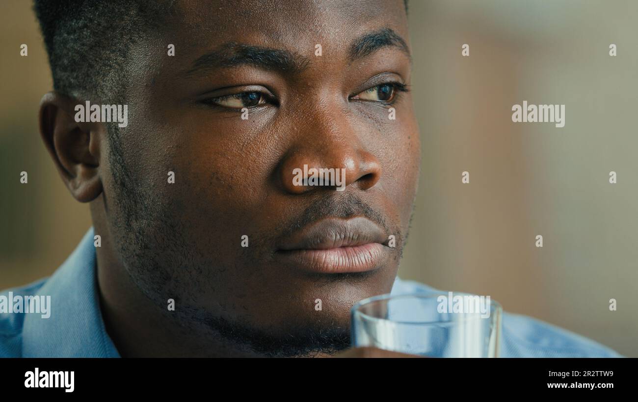 Close up African American ethnic man thoughtful businessman drink glass ...