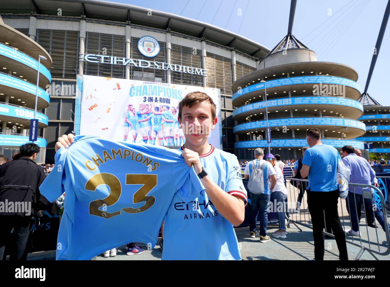 A Manchester City fan poses for a photo in front of a banner ...