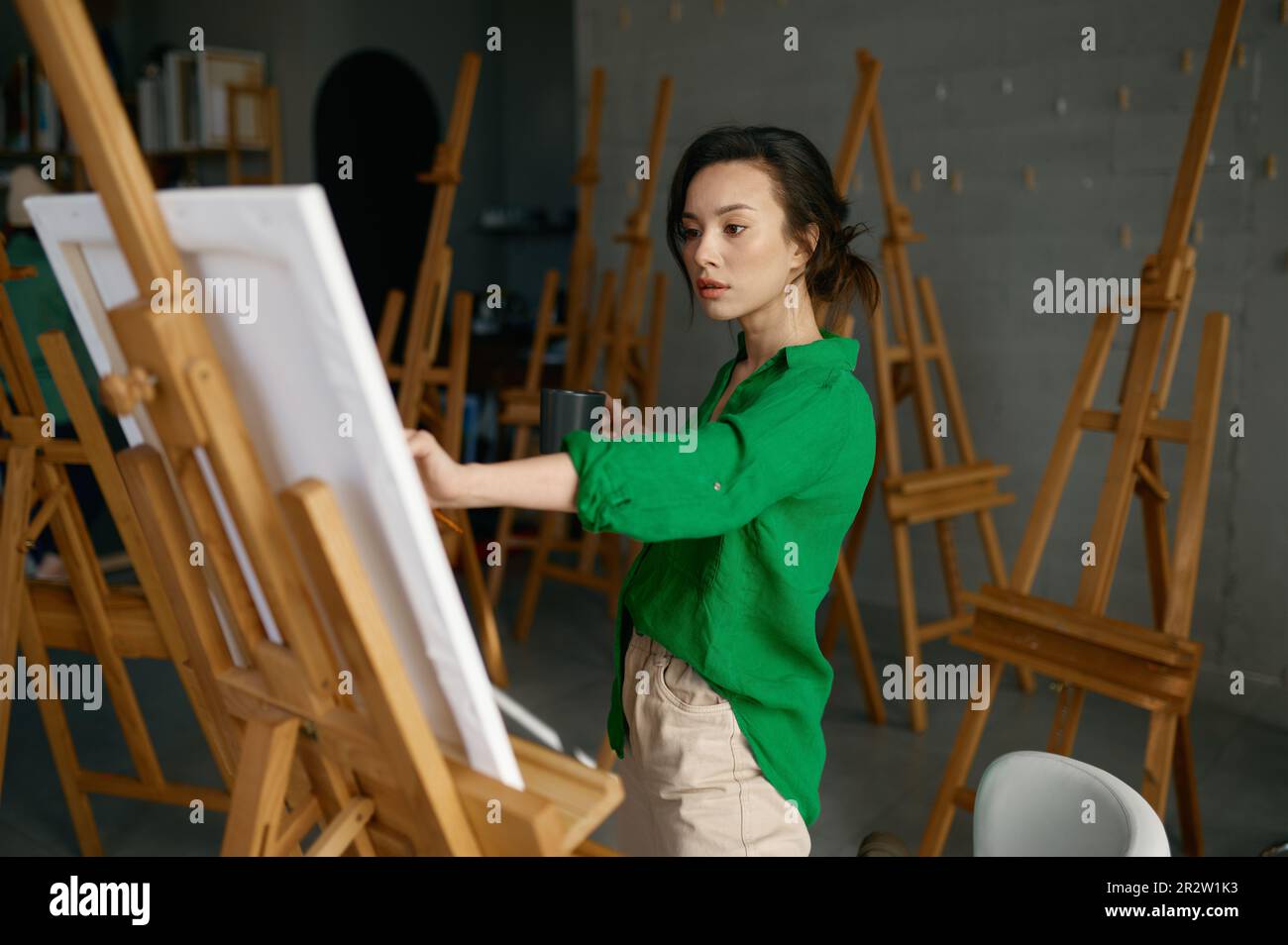Woman painting brush on canvas at workshop during art lesson class ...