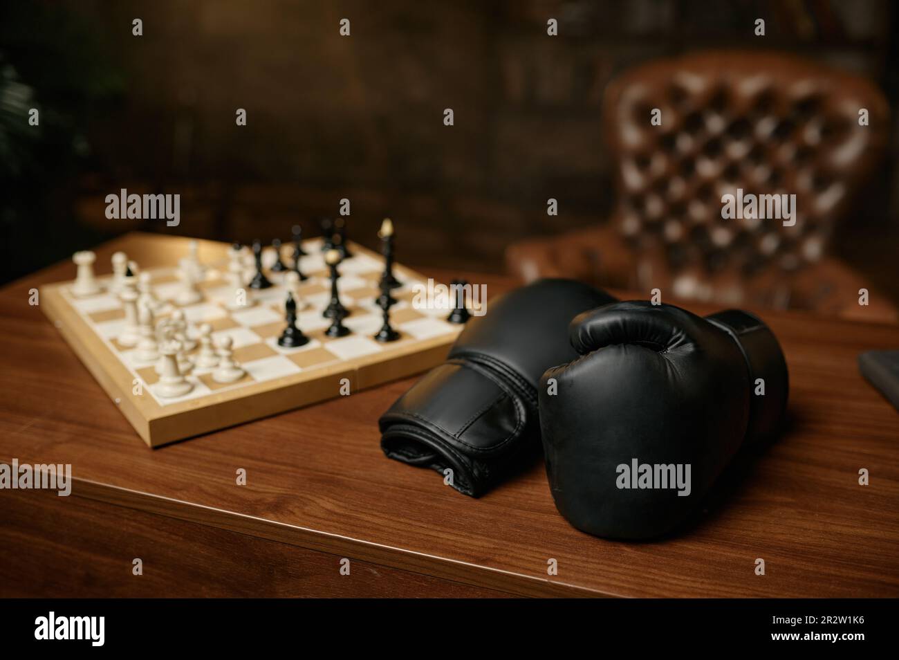 Table in room with boxer gloves and chessboard with chesspieces, chess ...