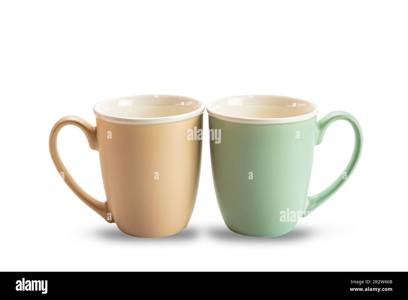 Side view of two empty ceramic coffee mugs brown and green isolated on ...