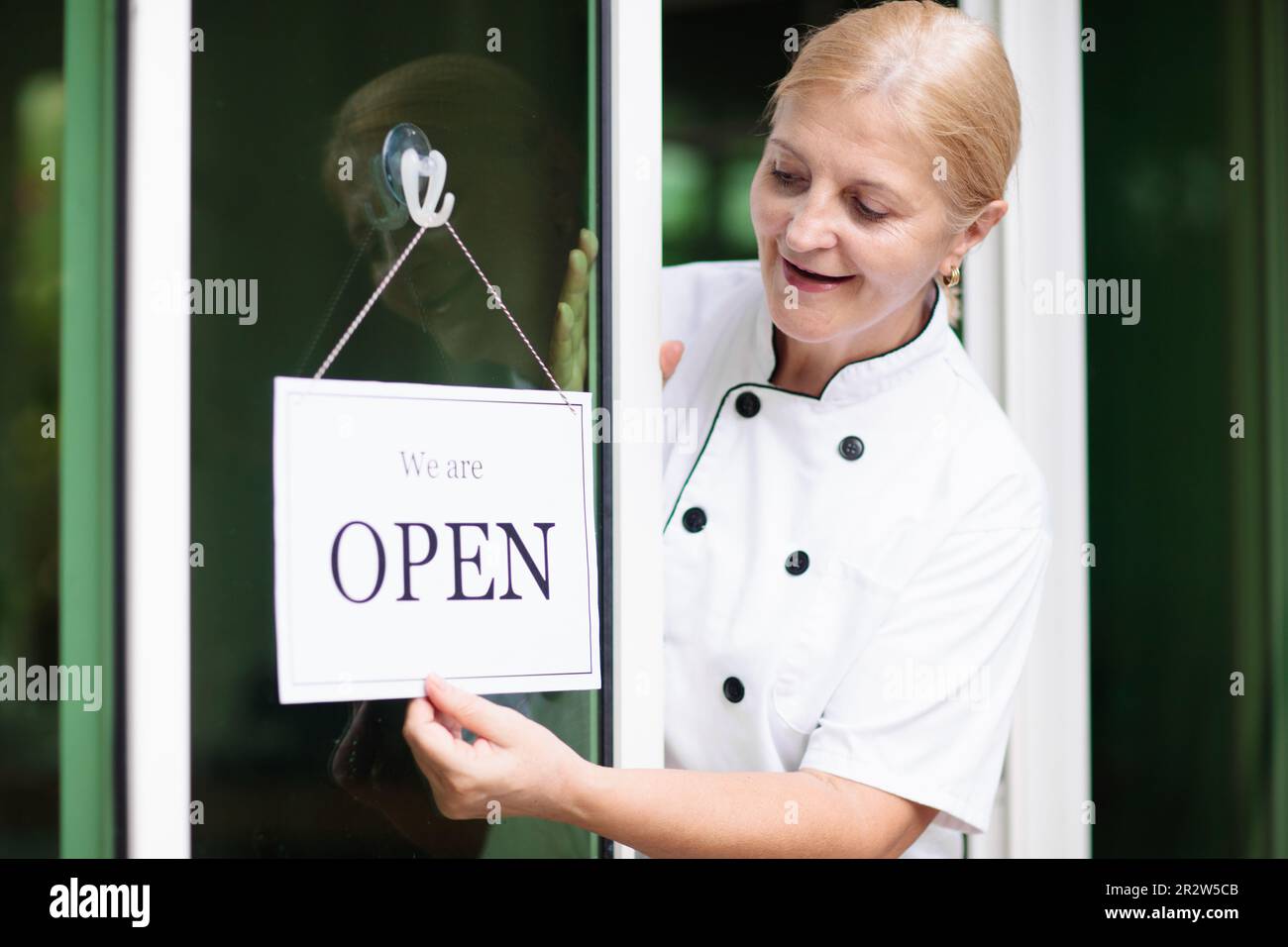 Cafe opening ceremony. Open sign on front door of restaurant or grocery ...