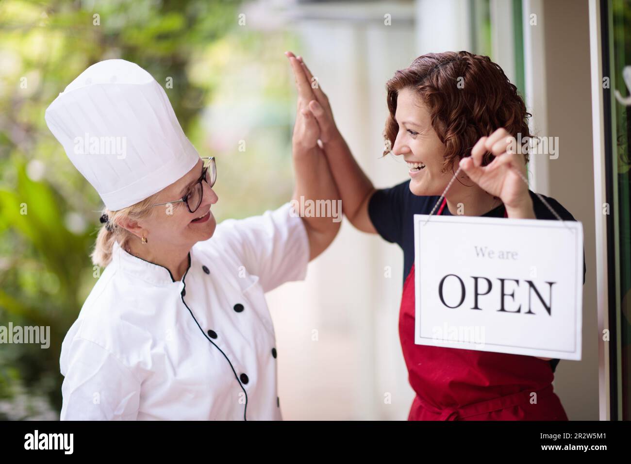 Cafe opening ceremony. Open sign on front door of restaurant or grocery ...