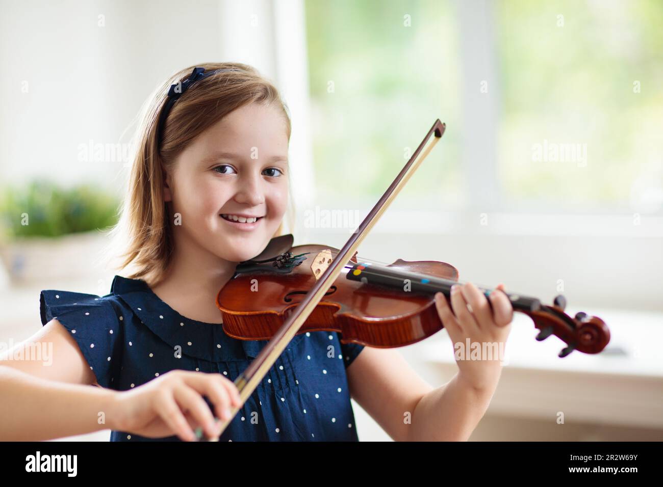 Child playing violin. Remote learning from home. Arts for kid. Little ...