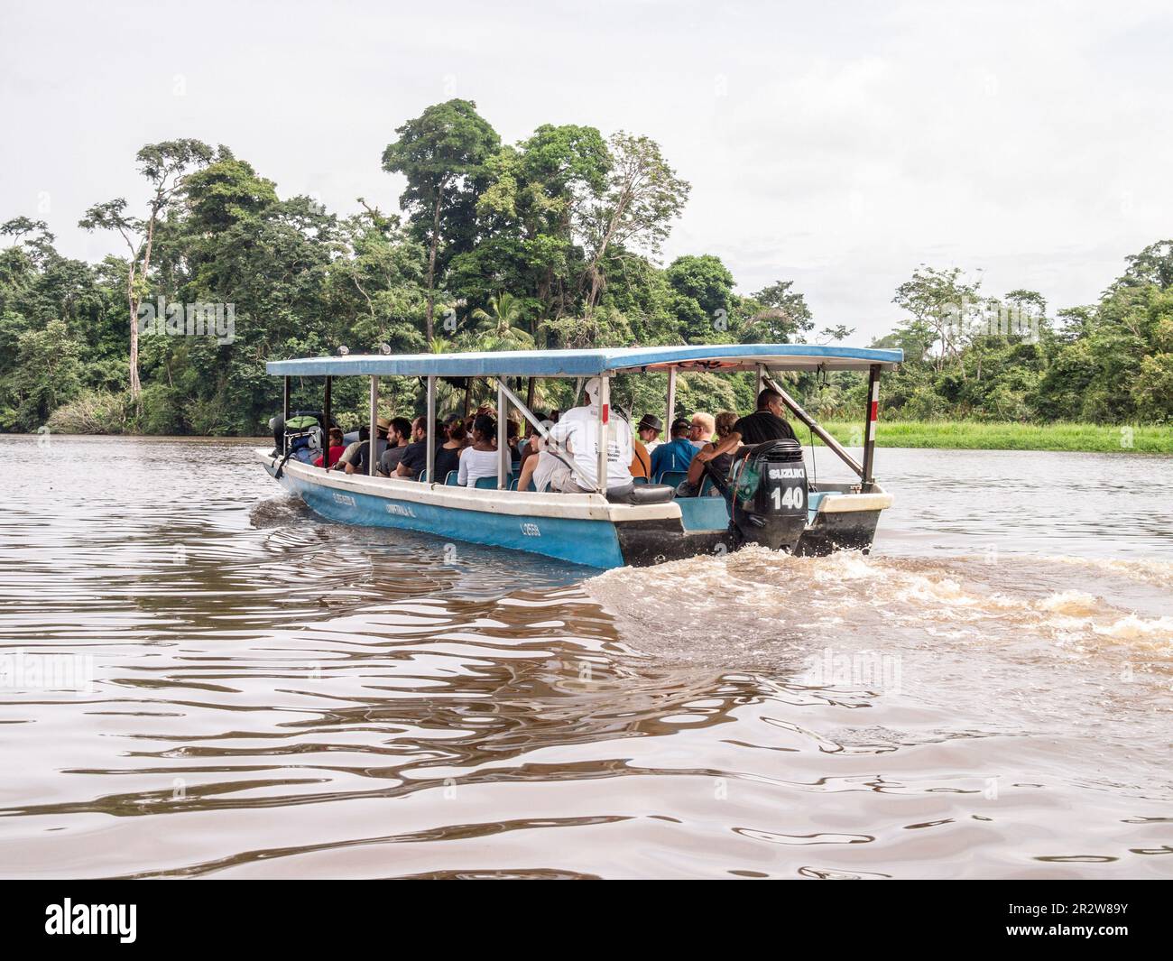 Boat loaded with tourists motoring up waterway in Tortuguero National ...