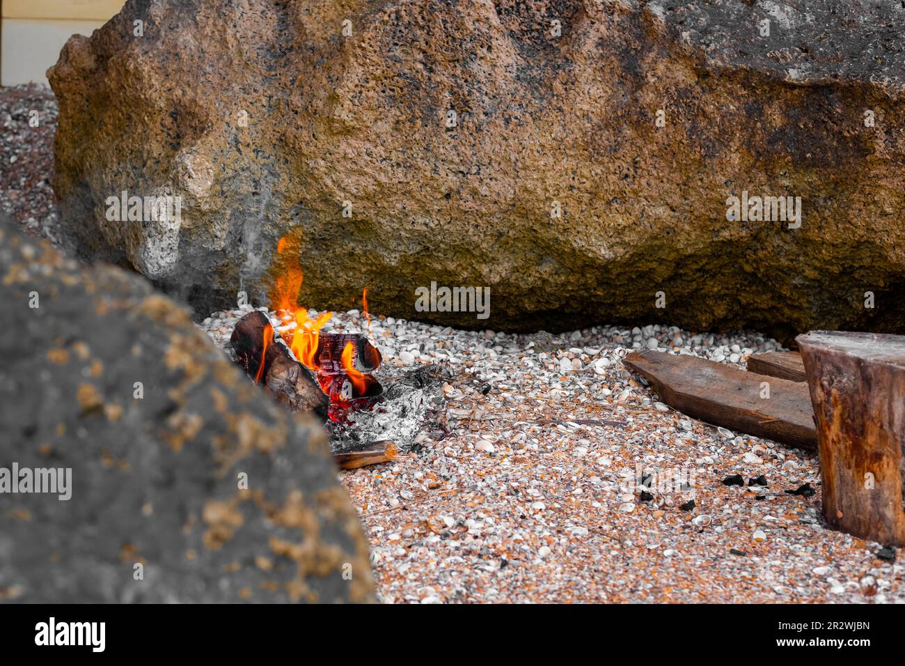 burning fire in a stone grotto on the seashore. Travel and tourism ...