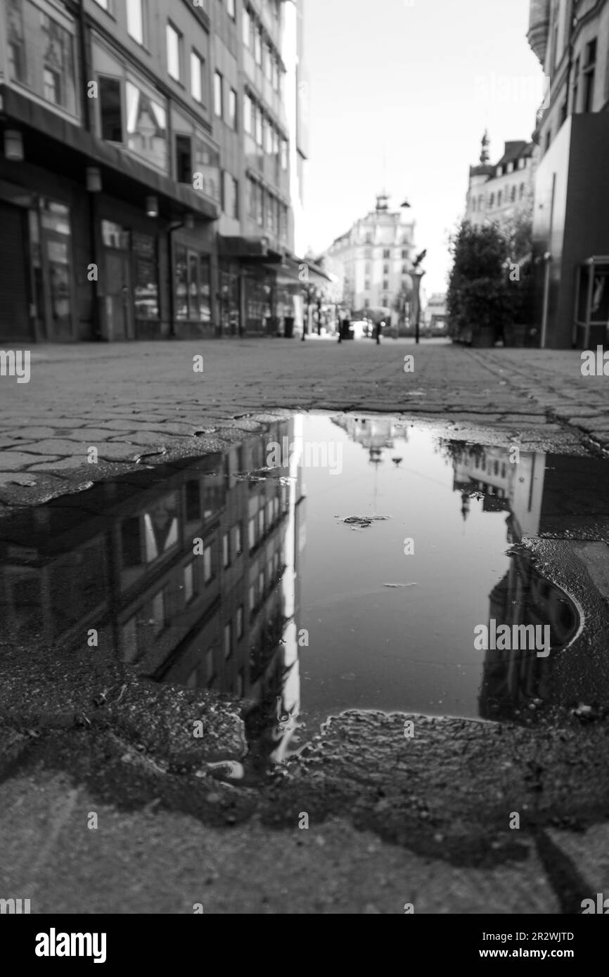 A puddle on a city street in black and white Stock Photo - Alamy