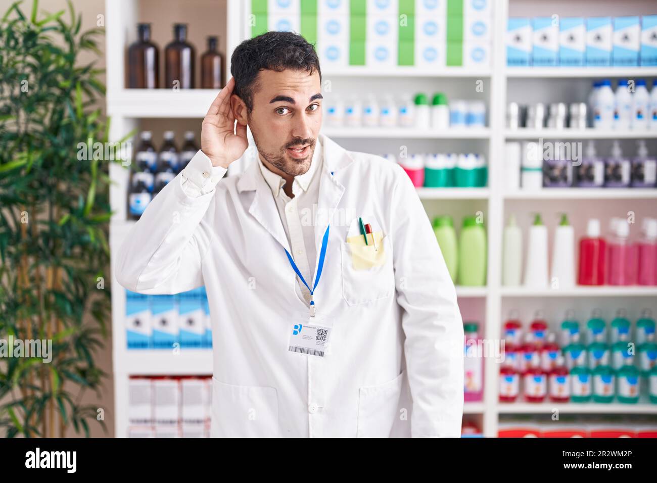 Handsome hispanic man working at pharmacy drugstore smiling with hand ...