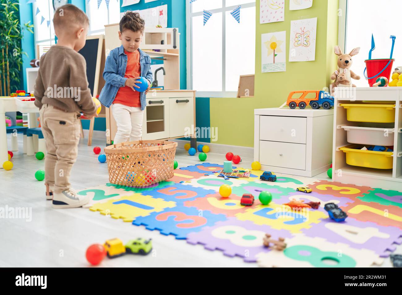 Adorable boys playing with balls standing at kindergarten Stock Photo ...